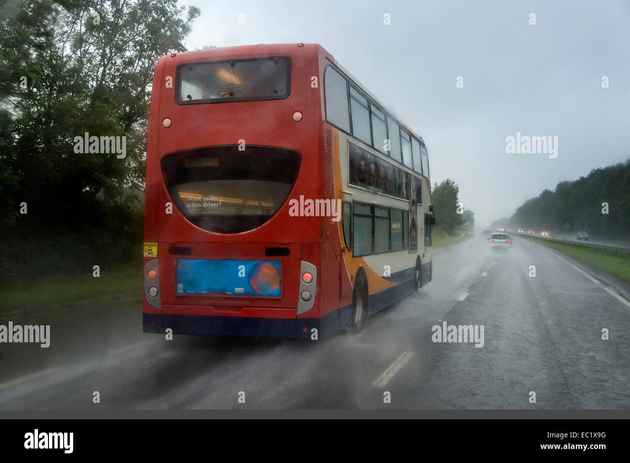 Red bus in the rain on the highway, Cornwall, England, United Kingdom ...