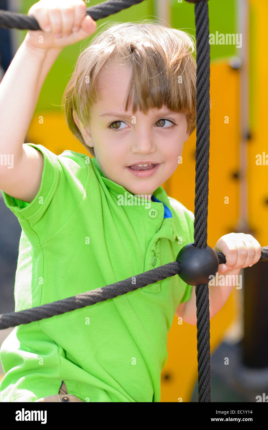 Happy kid climbing on rope ladder Stock Photo - Alamy