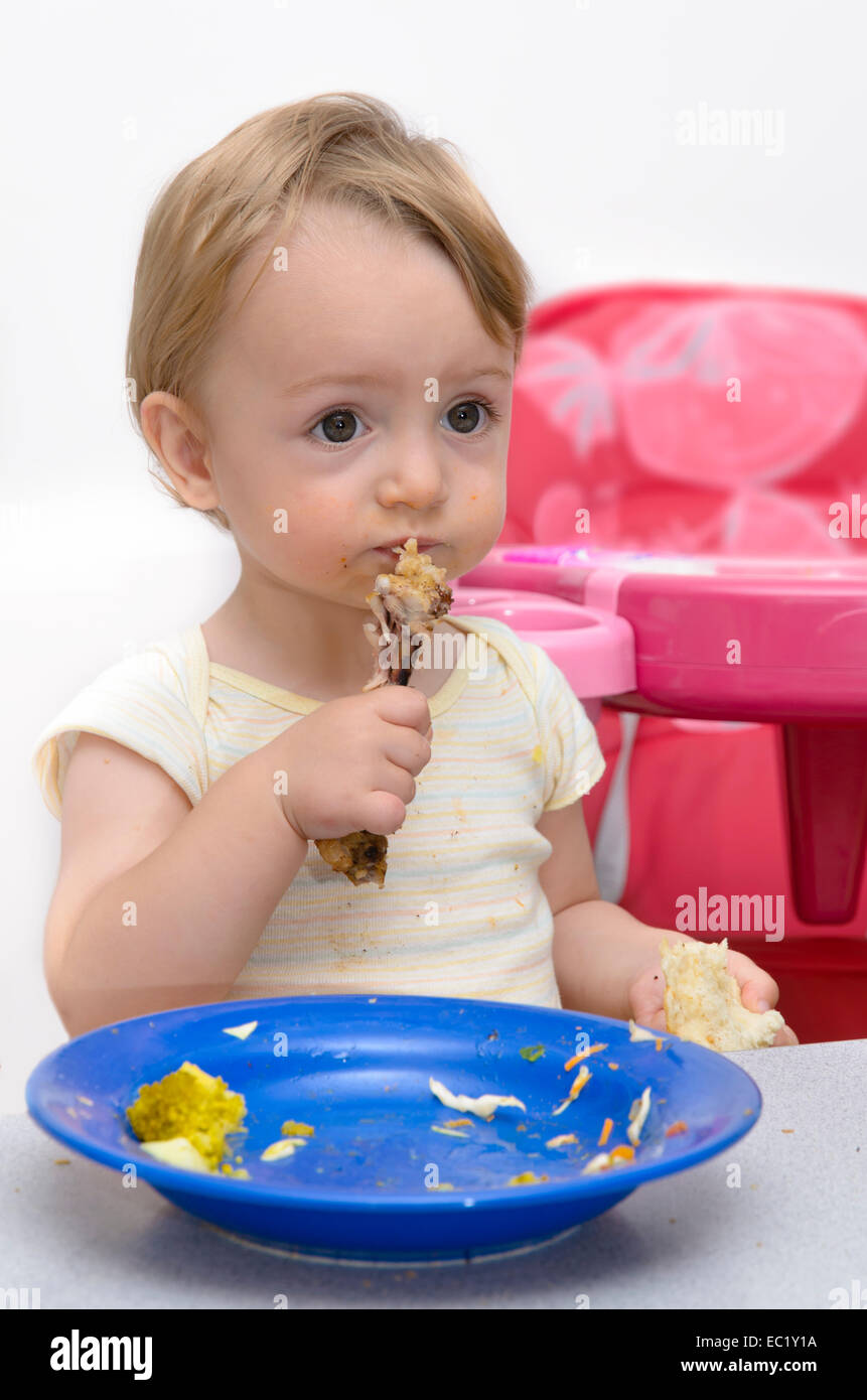 Portrait of a baby eating chicken meat and gets dirty Stock Photo - Alamy