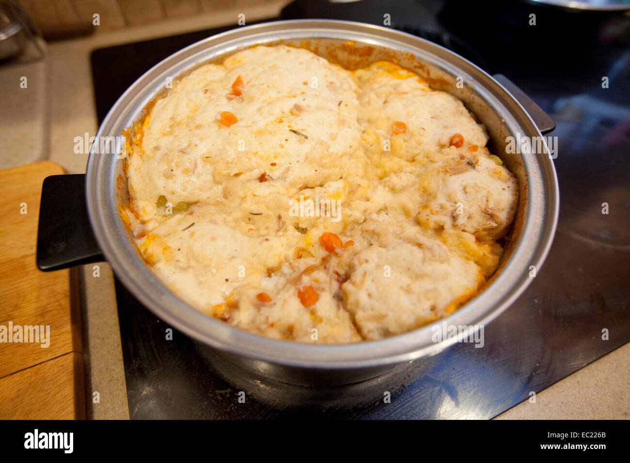 Thick dumplings in a turkey stew cooking on a stove top Stock Photo - Alamy