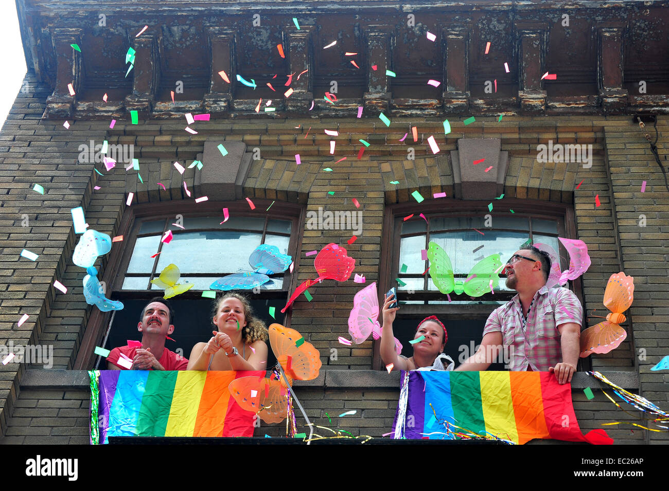 People look down from a open windows and throw confetti at the 2014 ...