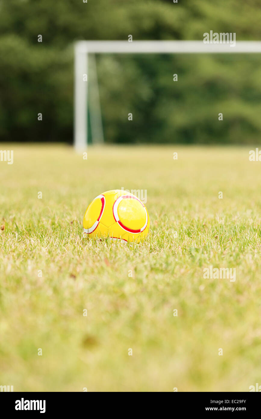 Empty football (soccer) field with yellow ball and goal Stock Photo - Alamy