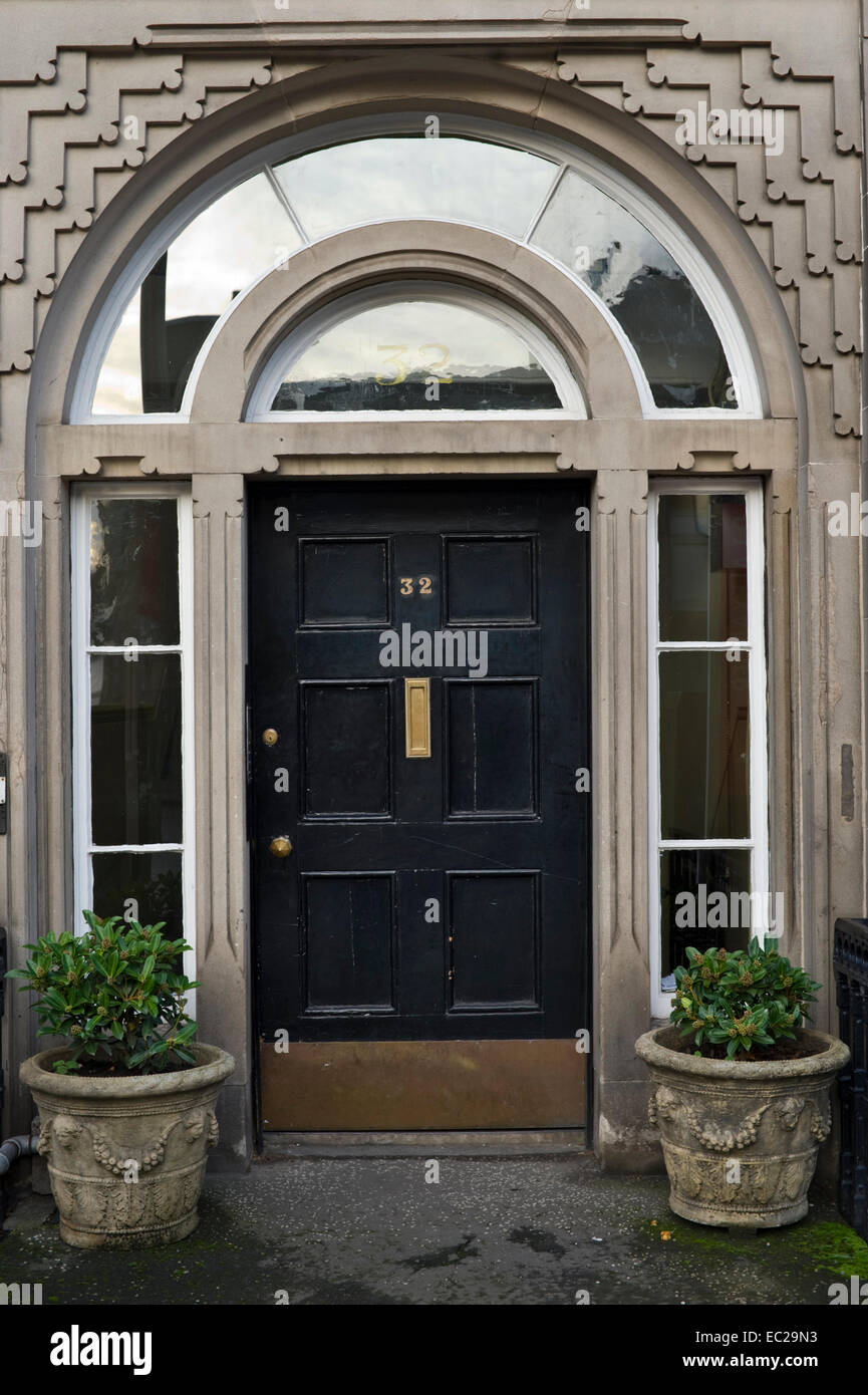 Black No 32 front door with pot shrubs outside of period house in city ...