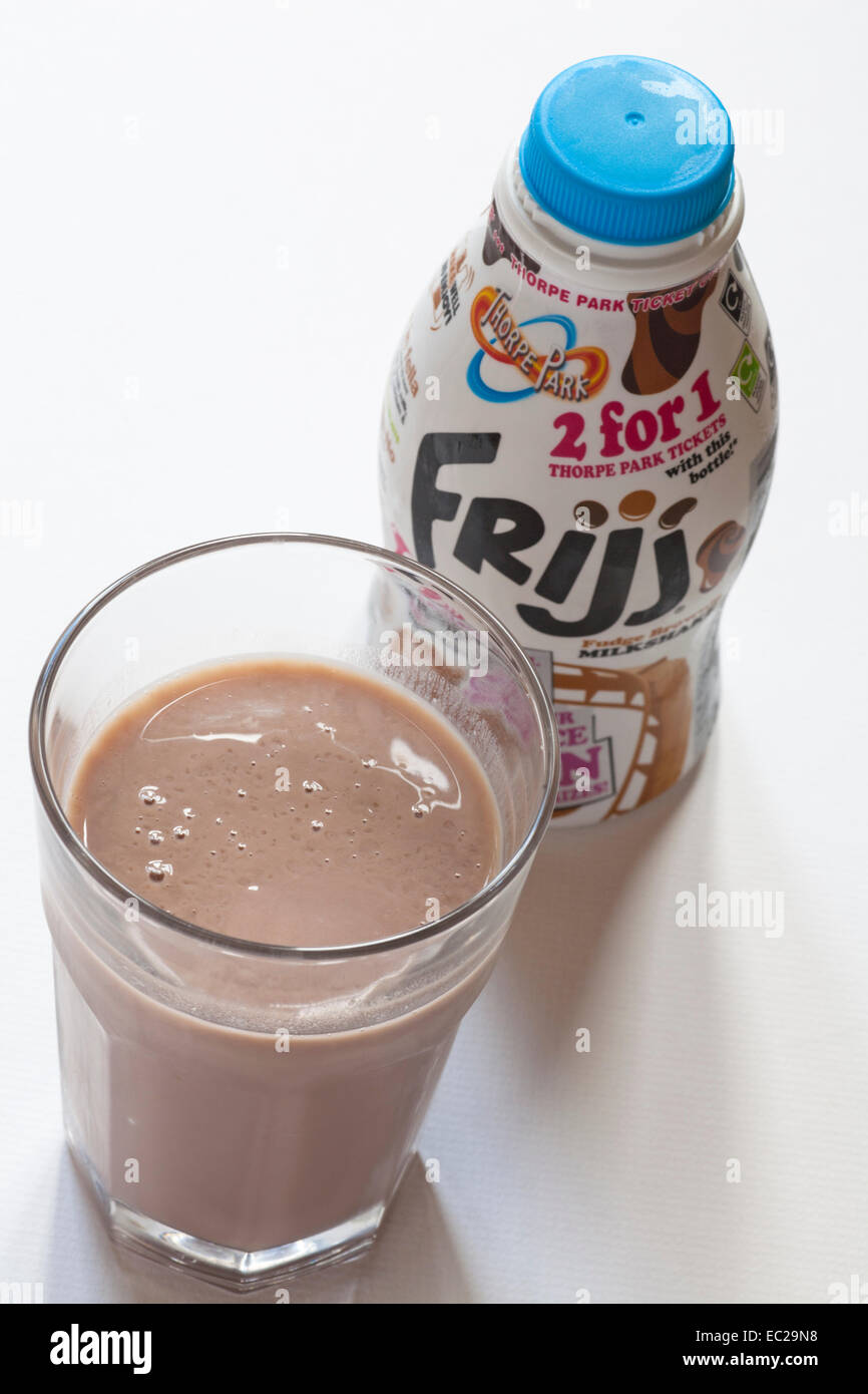 glass of Frijj Fudge Brownie milkshake with bottle set against white ...