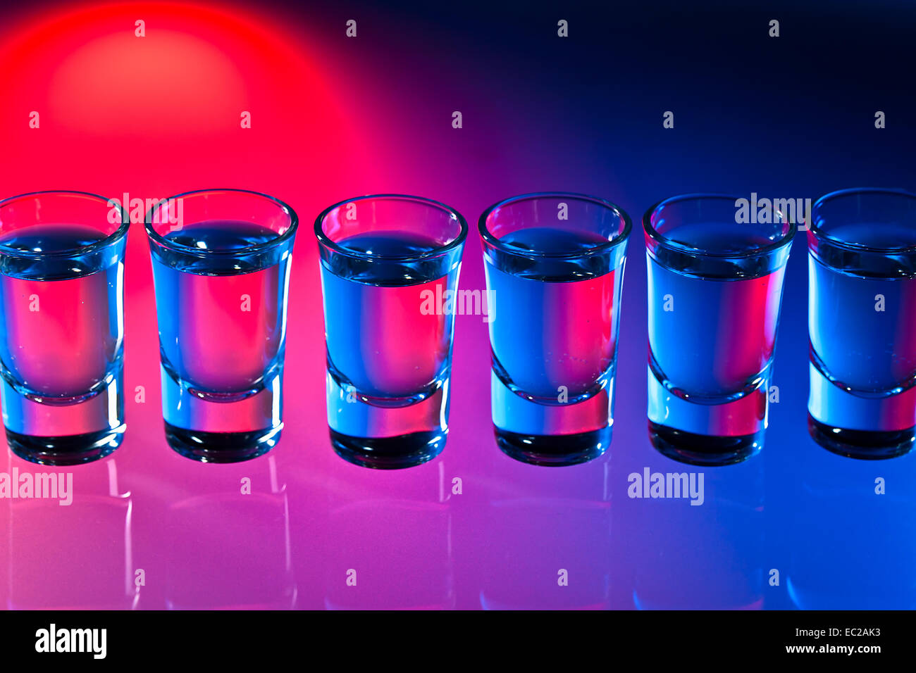 Glasses with an alcoholic drink on a glass table Stock Photo - Alamy