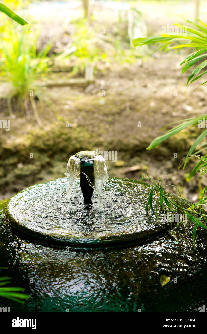 Water flow down into the large jar. Making of waterfall for garden ...