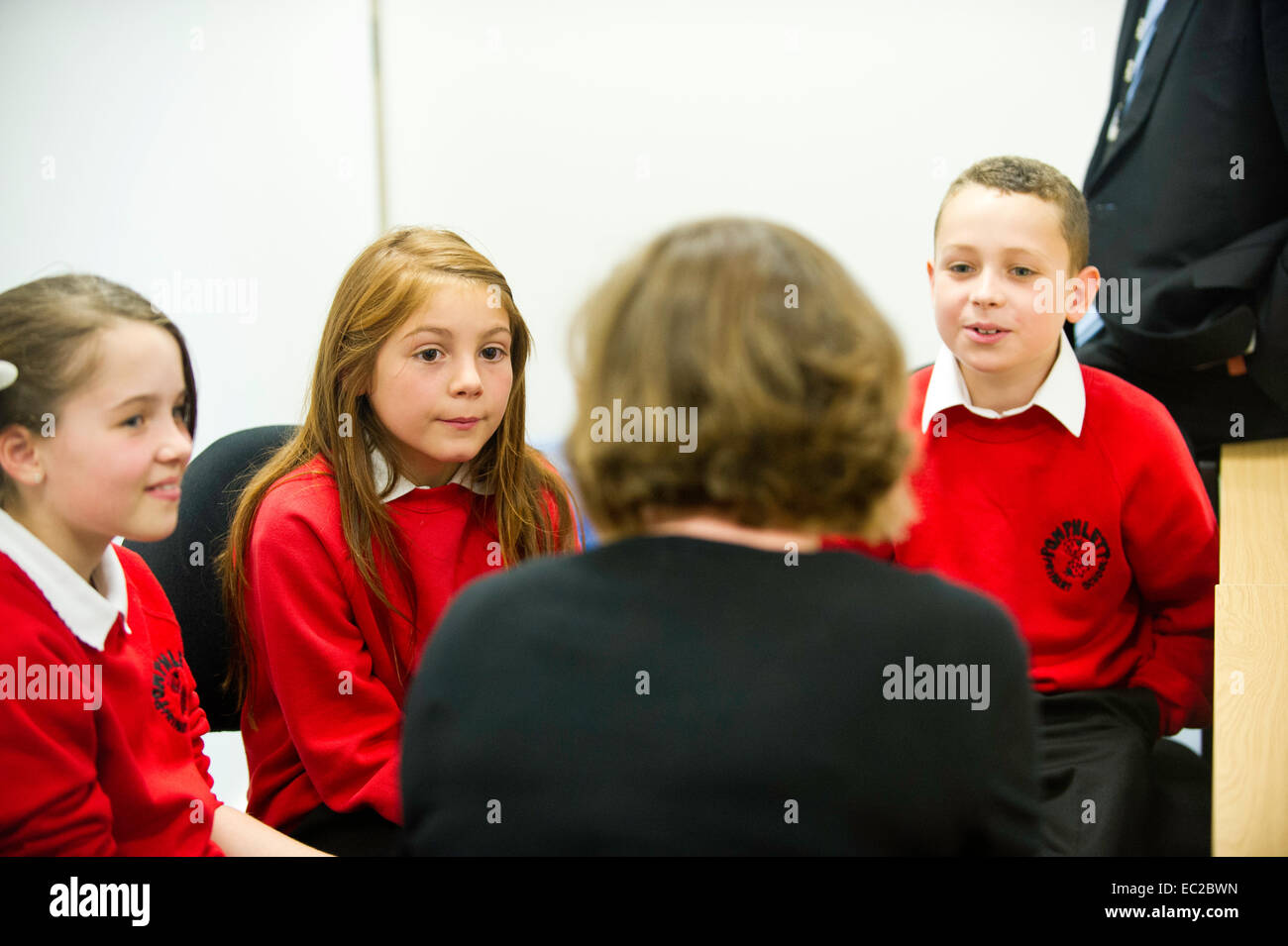 A teacher educating 3 children Stock Photo - Alamy
