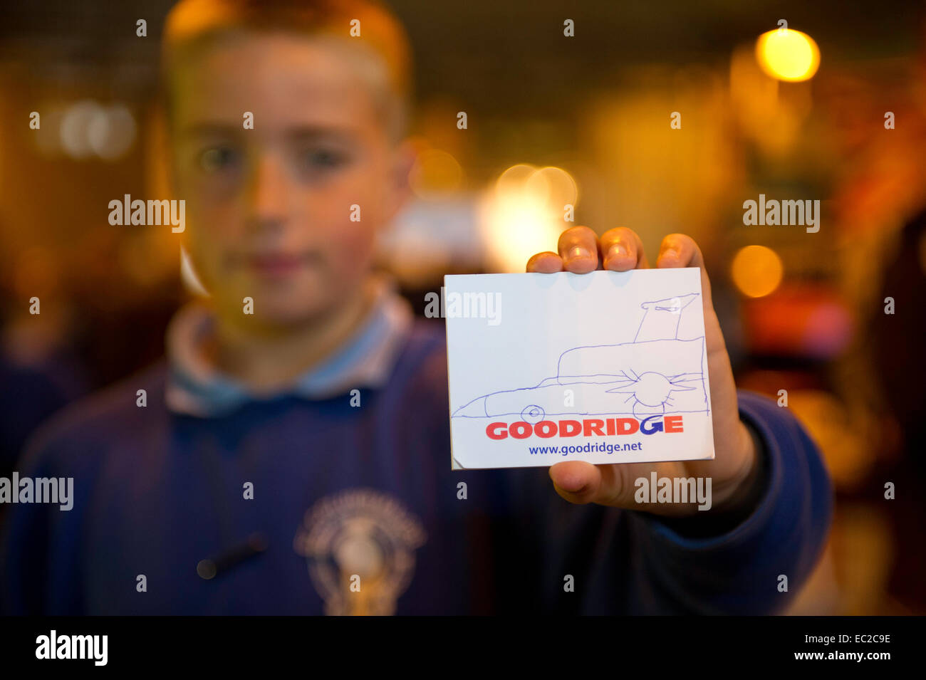 A young boy holding up a picture of a racing car towards camera. Boy ...