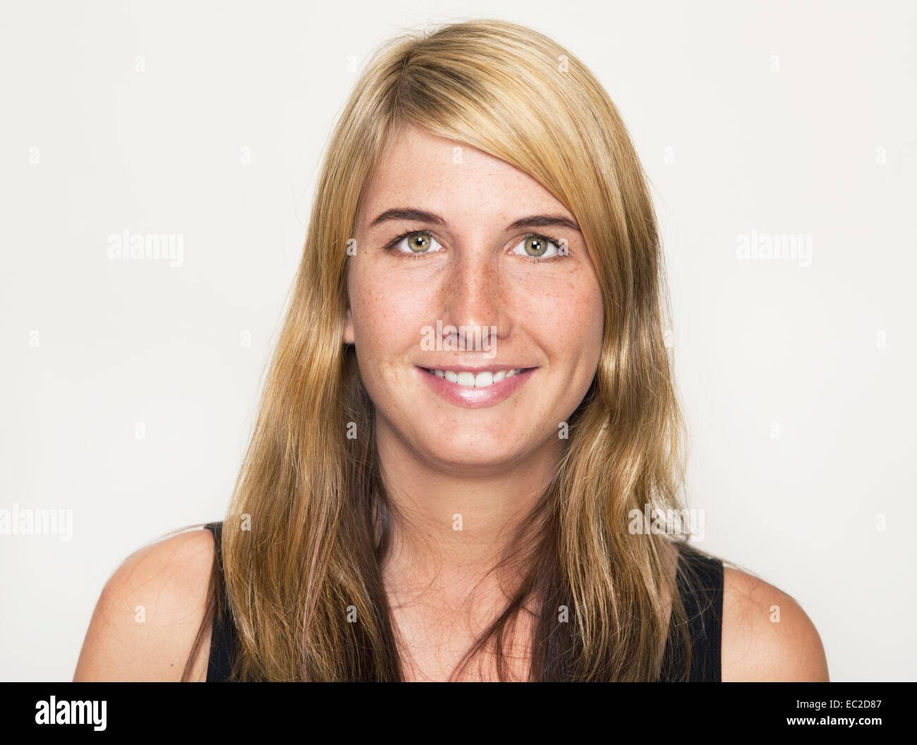 friendly young woman who looks into the camera with long straight hair ...