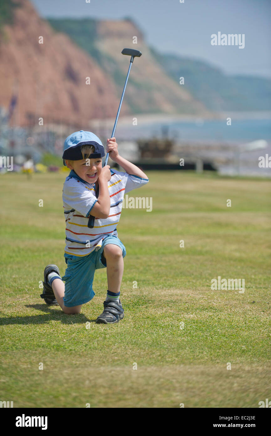 A young boy playing golf by the seaside Stock Photo - Alamy