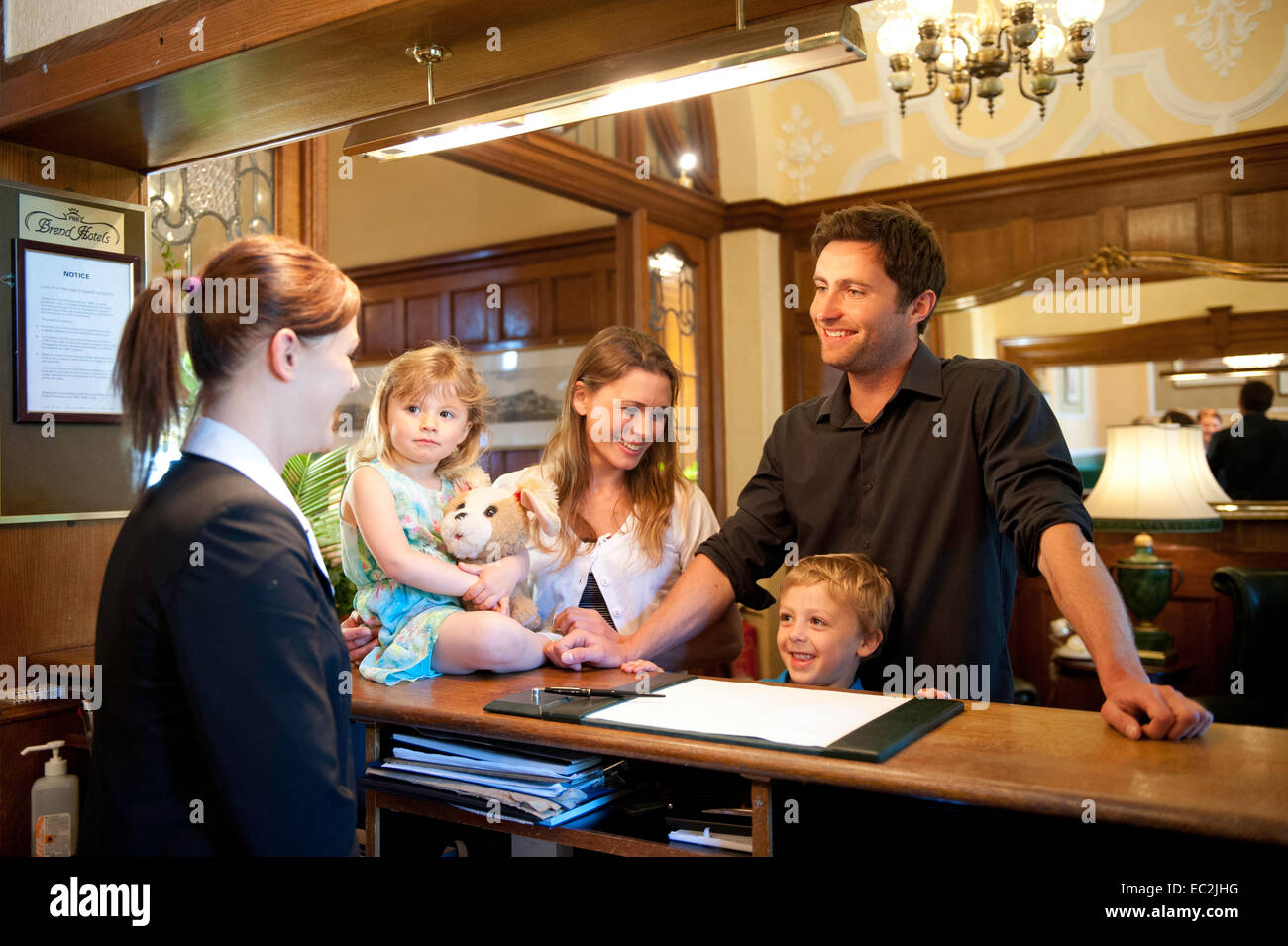 A young family checking in to a hotel in England Stock Photo - Alamy