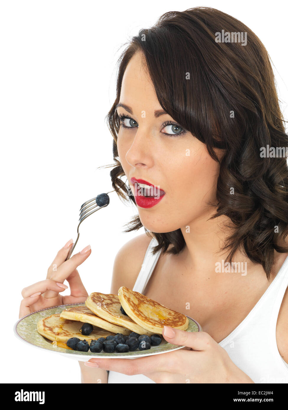 Young Woman Eating Blueberries with Pancakes and Syrup Stock Photo - Alamy