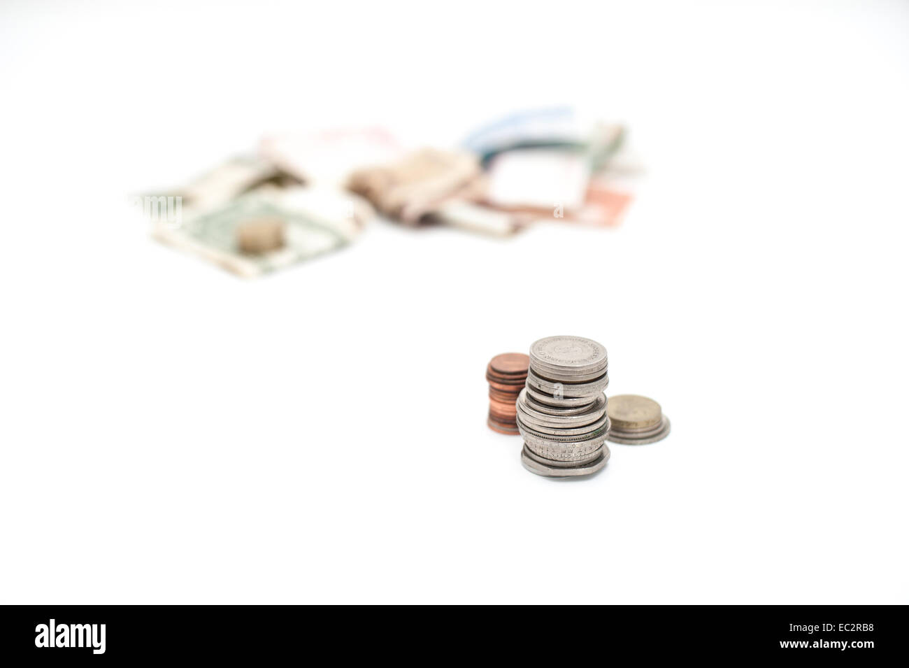Three piles of coins, gold, silver, and bronze, with out of focus money ...