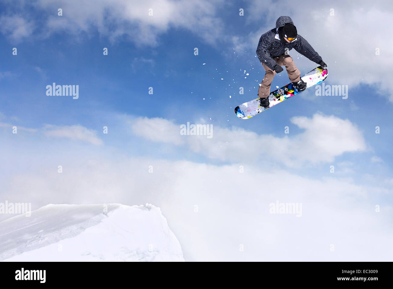 Jumping snowboarder through air on blue sky background Stock Photo - Alamy