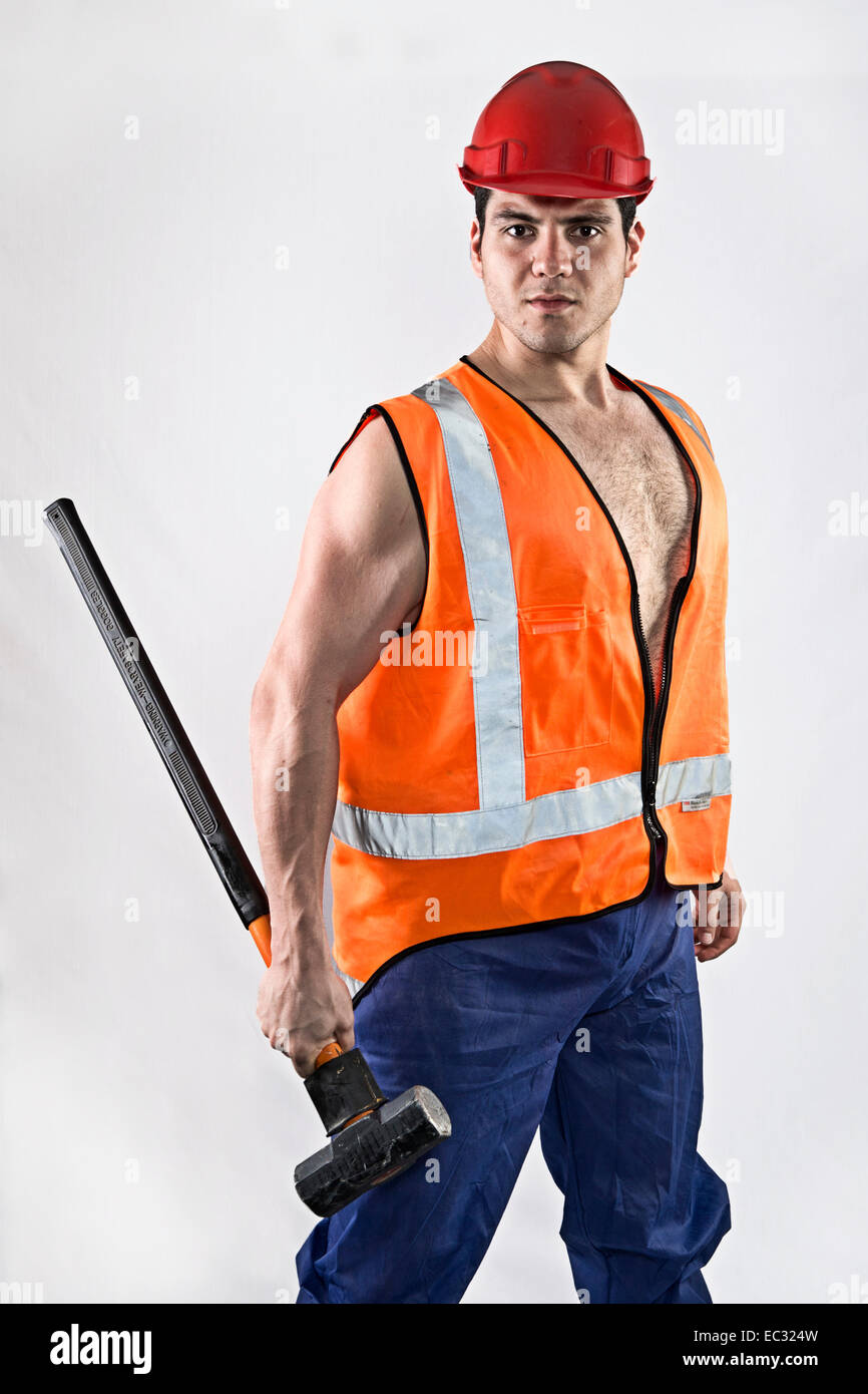 Young fit male shirtless workman with sledge hammer wearing a ...