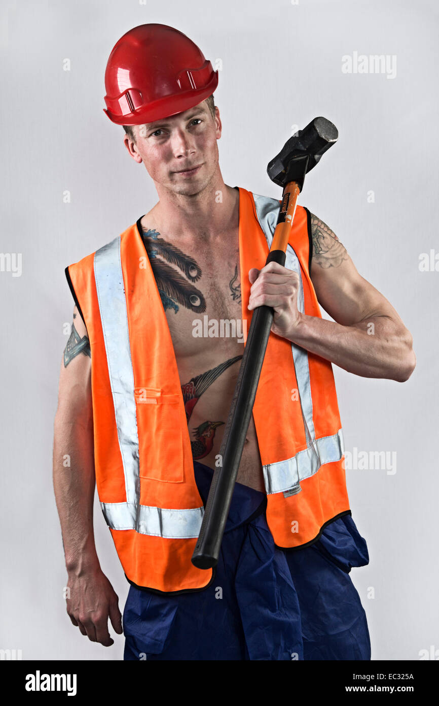 Young fit male shirtless workman with sledge hammer wearing a ...