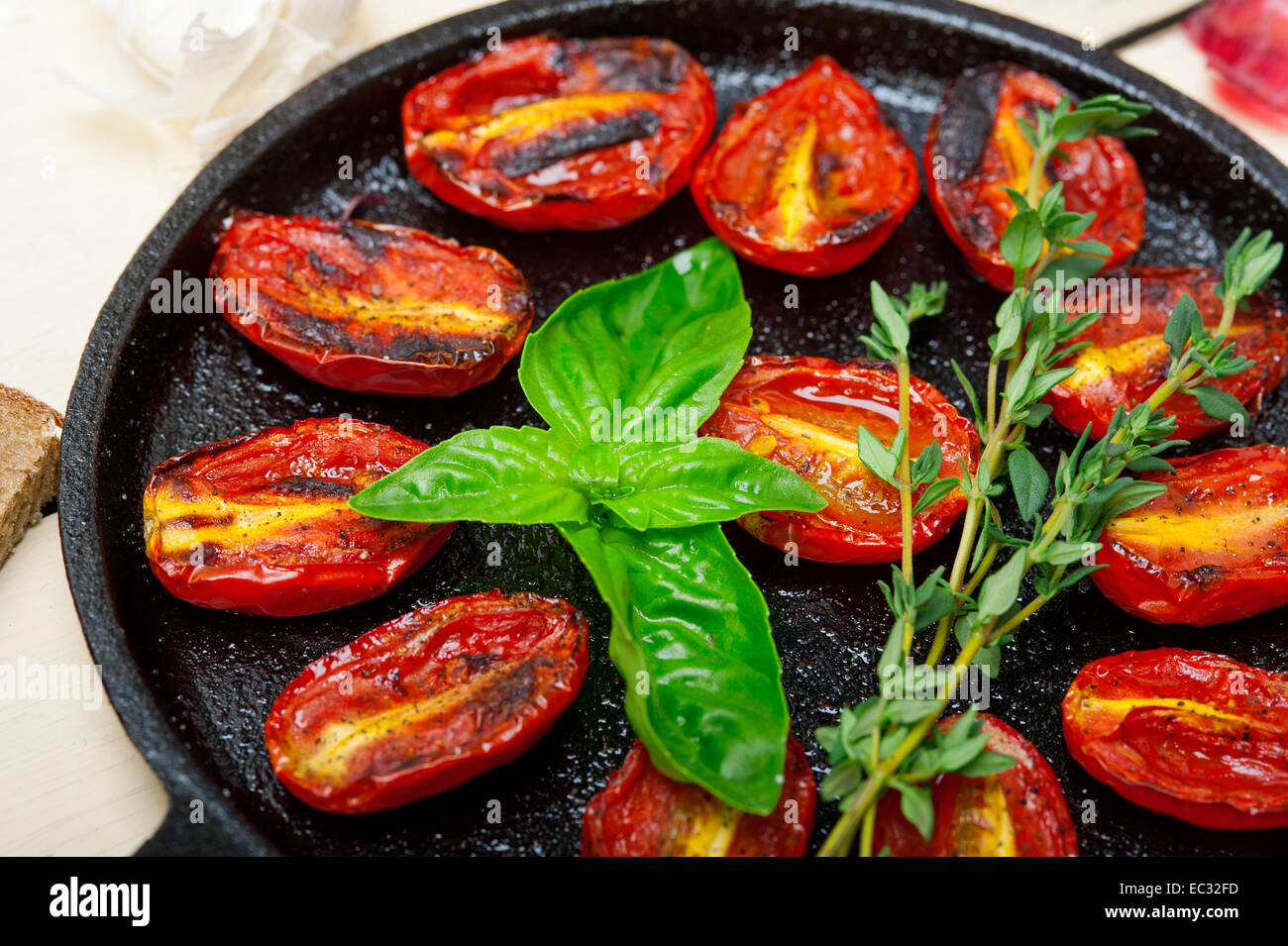 oven baked cherry tomatoes with basil and thyme on a cast iron skillet ...