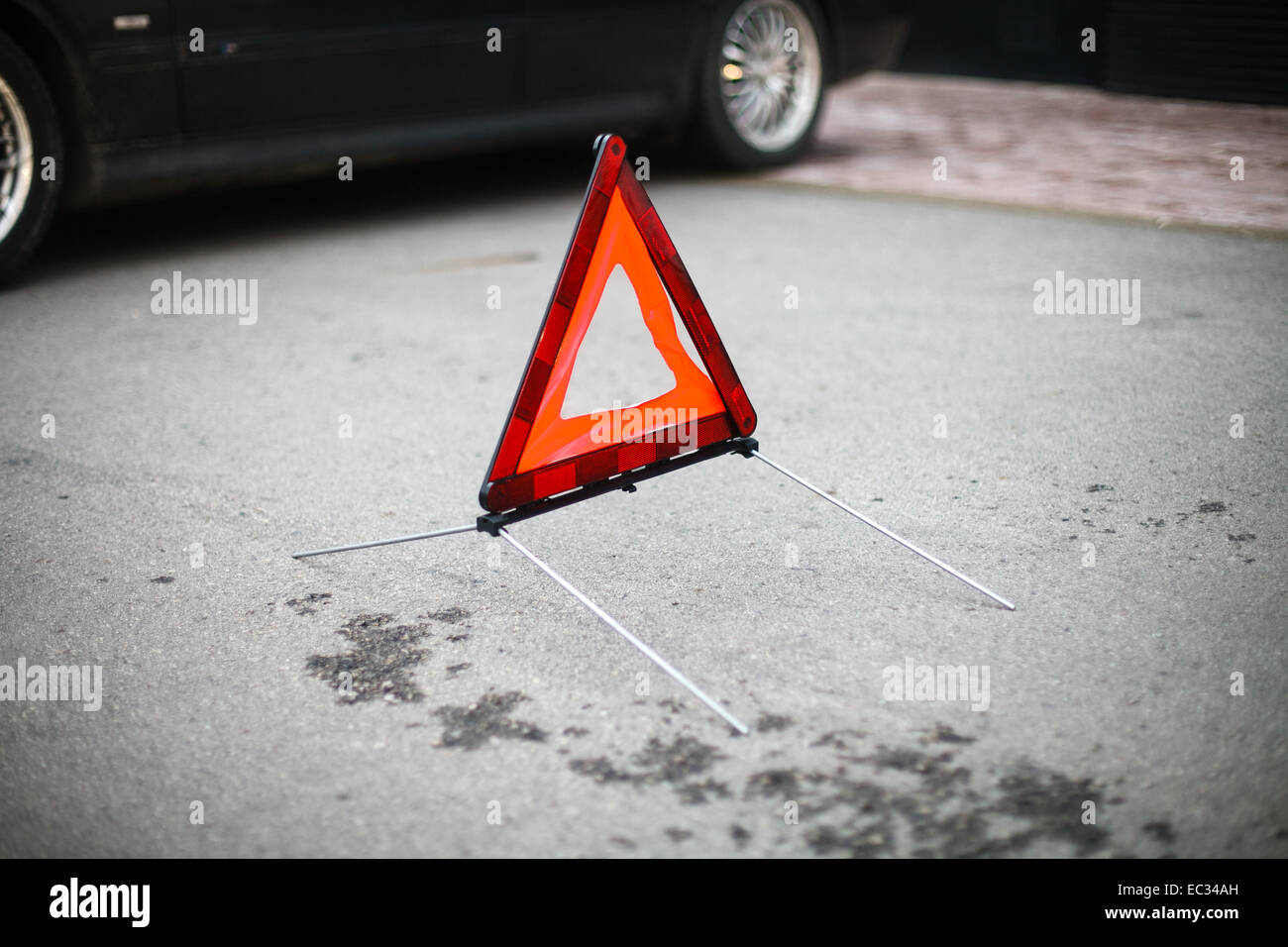 Warning triangle on asphalt. Car in a background Stock Photo - Alamy