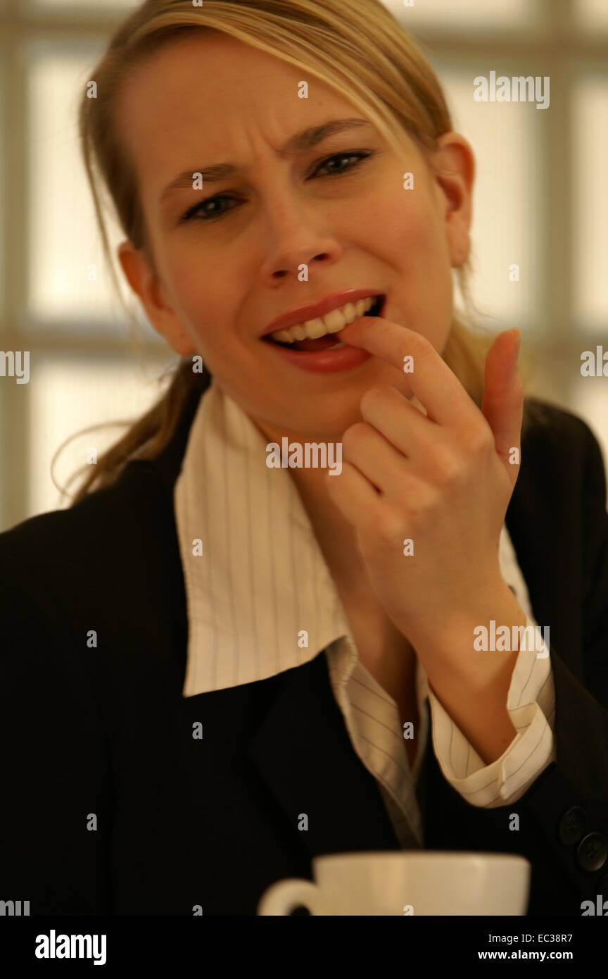 Woman with finger in mouth Stock Photo - Alamy
