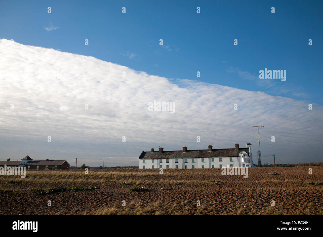 Frontal clouds passing over Coastguard Cottages shingle beach at ...