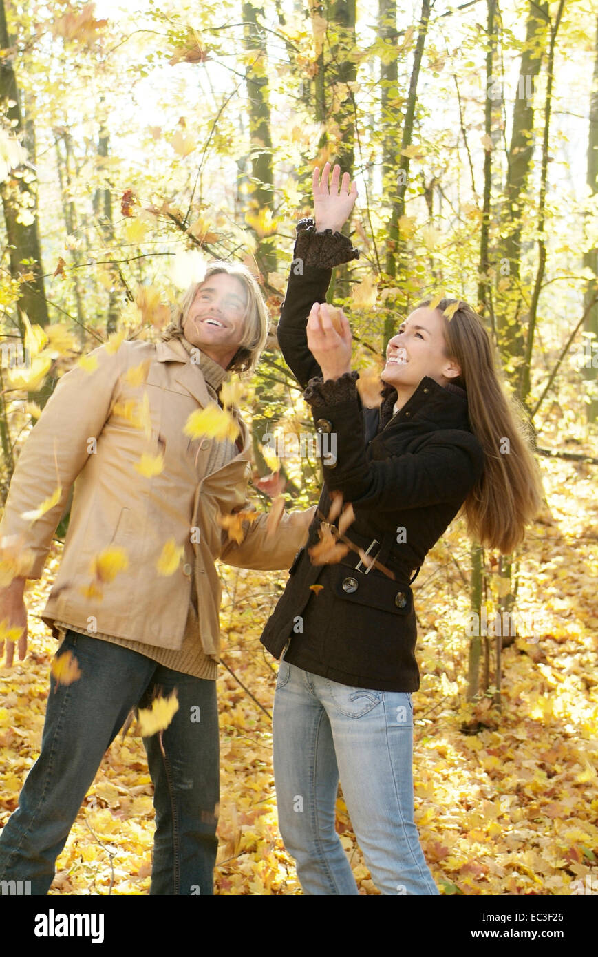 Young couple in autumn forest throwing leaves Stock Photo - Alamy