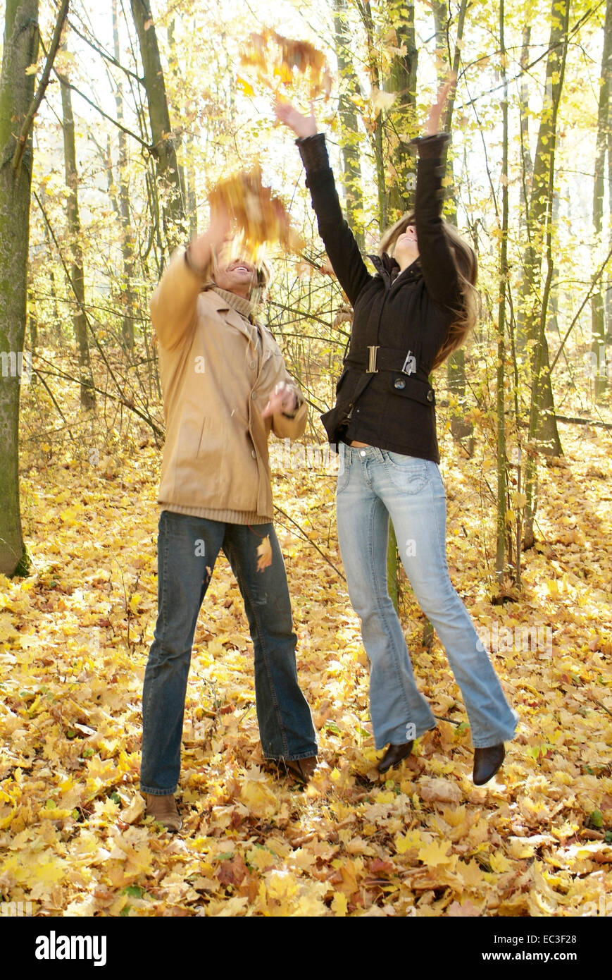 Young couple in autumn forest throwing leaves Stock Photo - Alamy