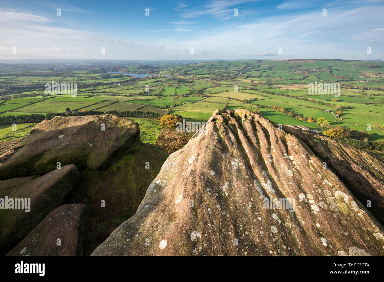 Weathered gritstone rocks on the summit of Hen Cloud with view across a ...