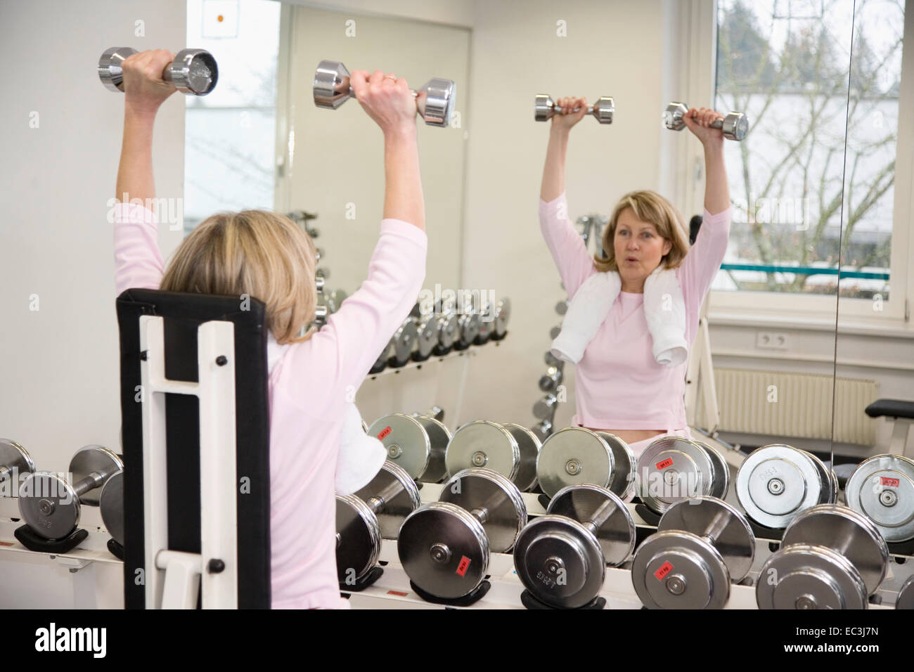 Woman trains with Bar Bells Stock Photo - Alamy