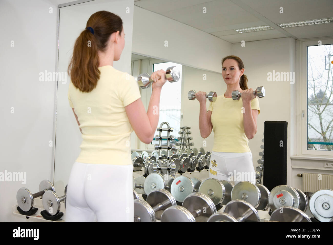 Woman trains with Bar Bells Stock Photo - Alamy