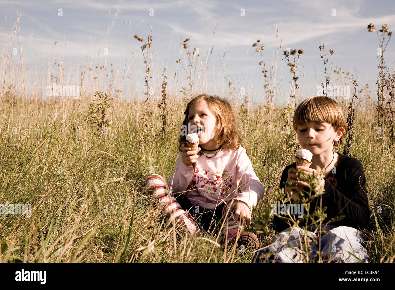 Children sitting in Meadow Stock Photo - Alamy