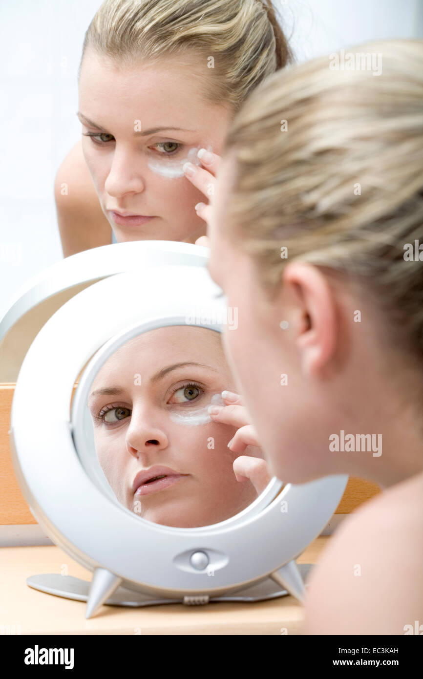 Woman applying Lotion on her Face Stock Photo - Alamy