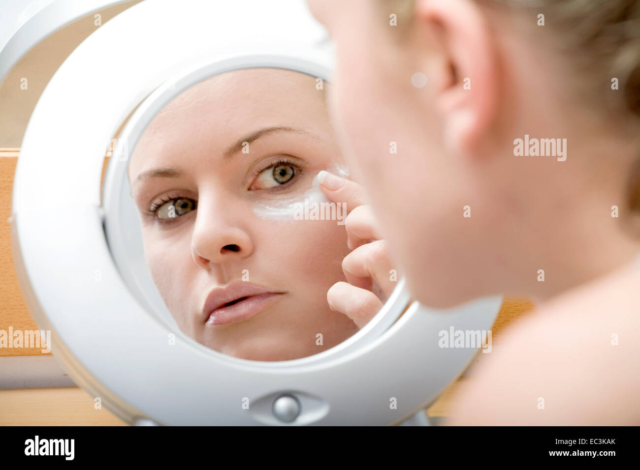 Woman applying Lotion on her Face Stock Photo - Alamy