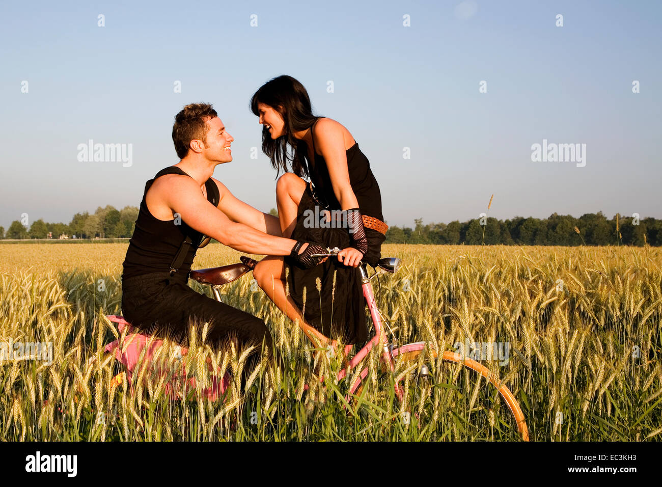 Couple with Bike in Corn Field Stock Photo - Alamy