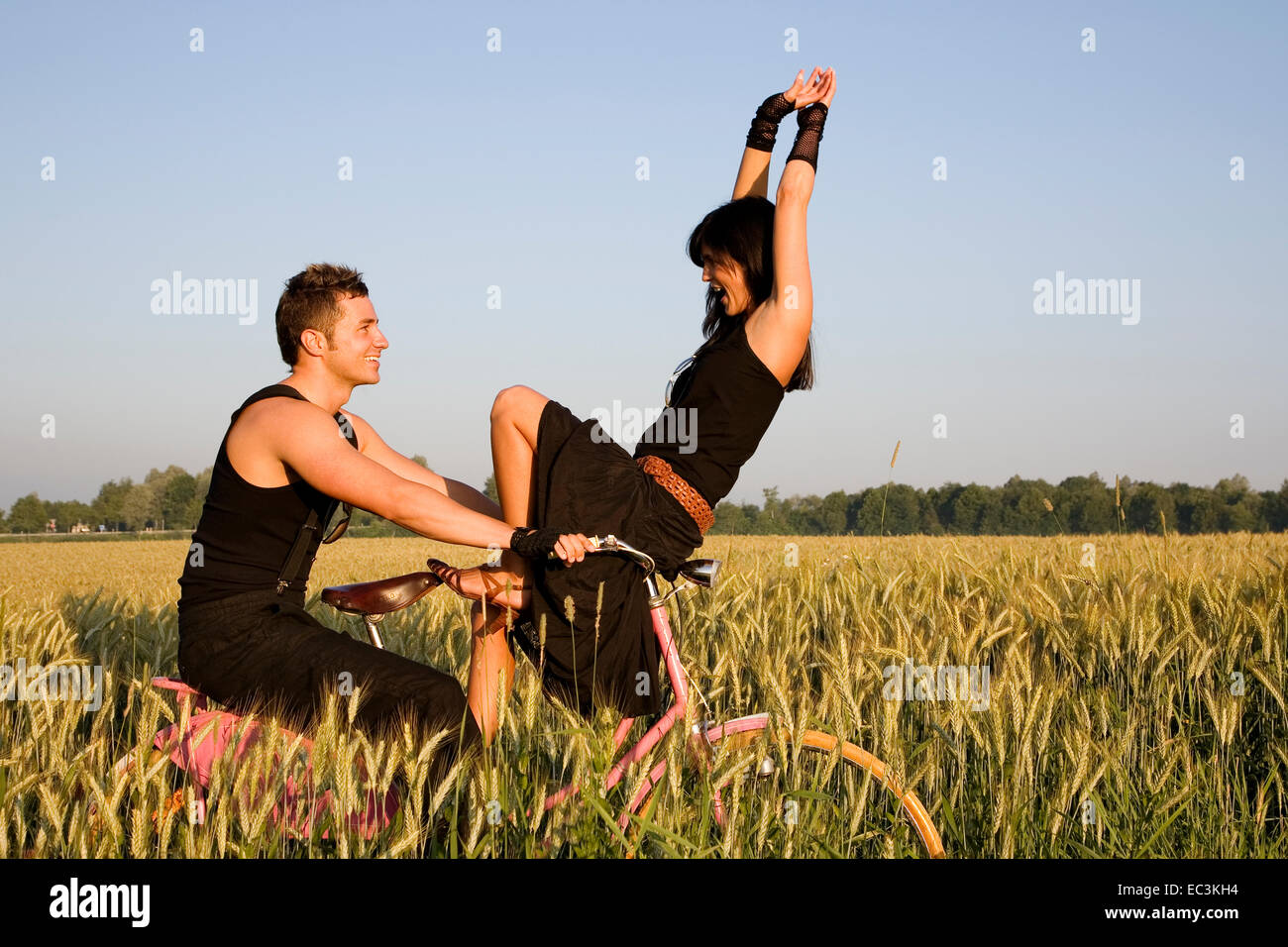 Couple with Bike in Corn Field Stock Photo - Alamy
