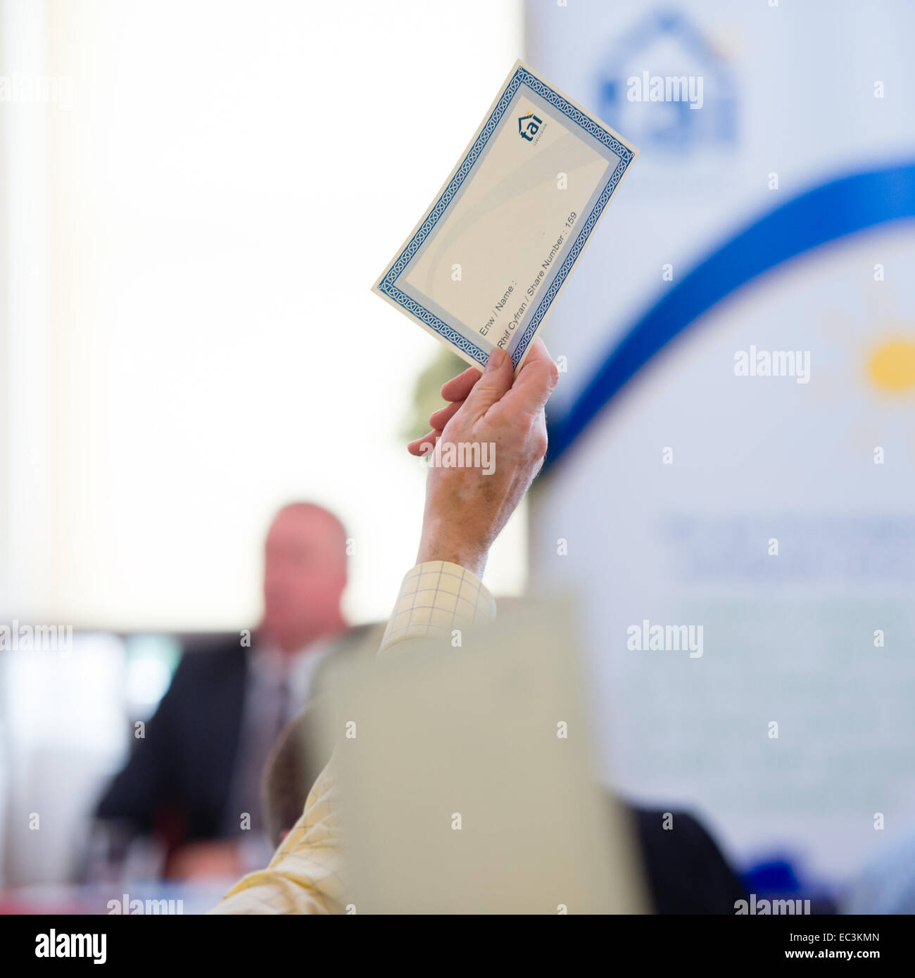 Tenants holding up their shareholder cards to vote at the AGM of Tai ...