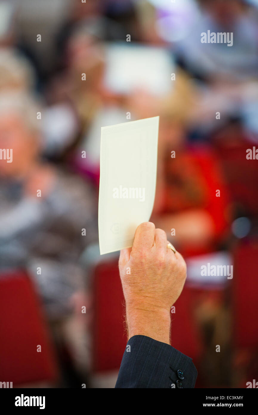 Tenants holding up their shareholder cards to vote at the AGM of Tai ...