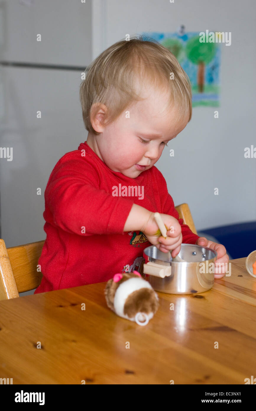 Small Child playing with Pot Stock Photo - Alamy