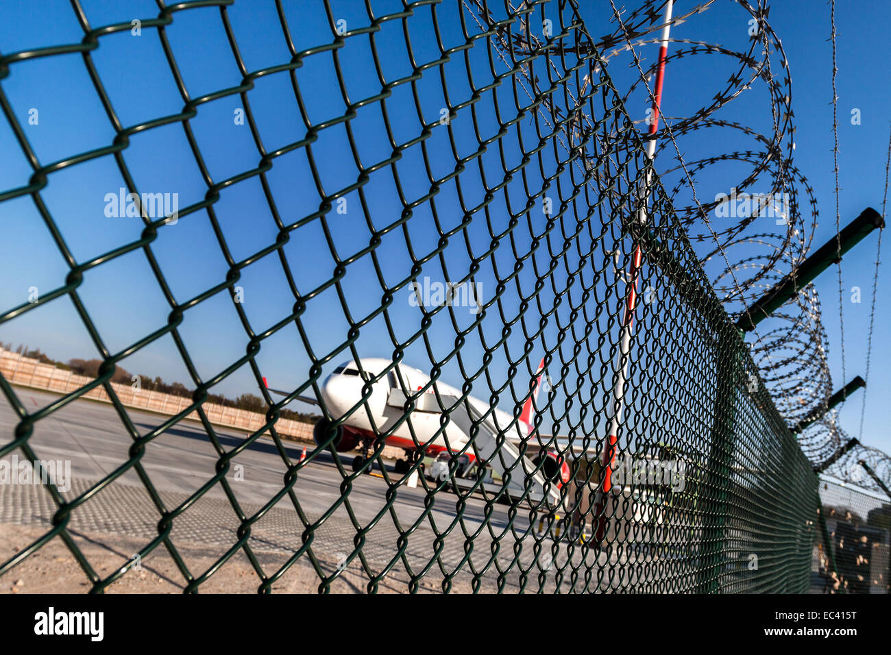 Aircraft behind a wire mesh fence Stock Photo - Alamy