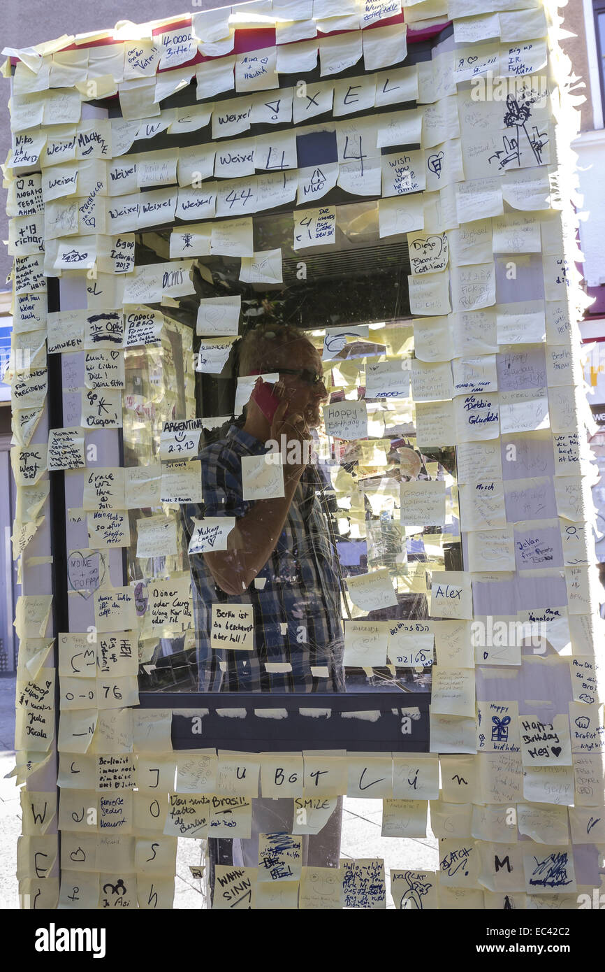 with sticky notes pasted phone booth in Berlin Stock Photo - Alamy