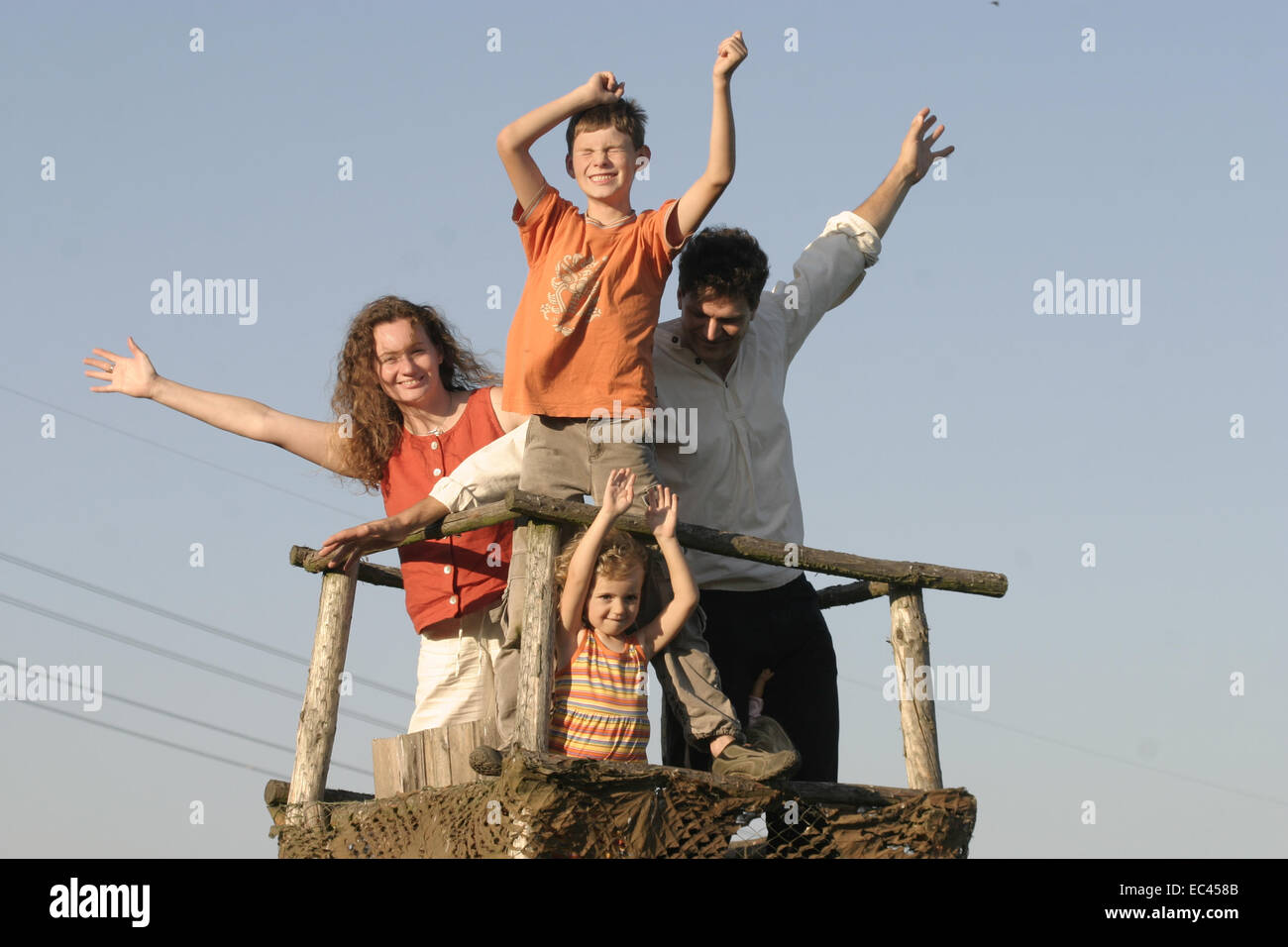 Happy Family waving down from Raised Stand Stock Photo - Alamy