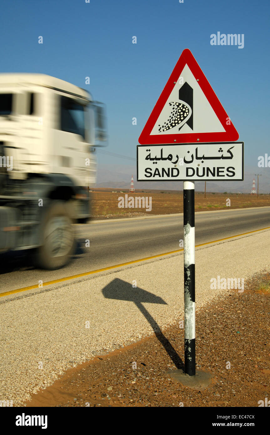 Road sign warning in English and Arabic of shifting sand dunes at a ...