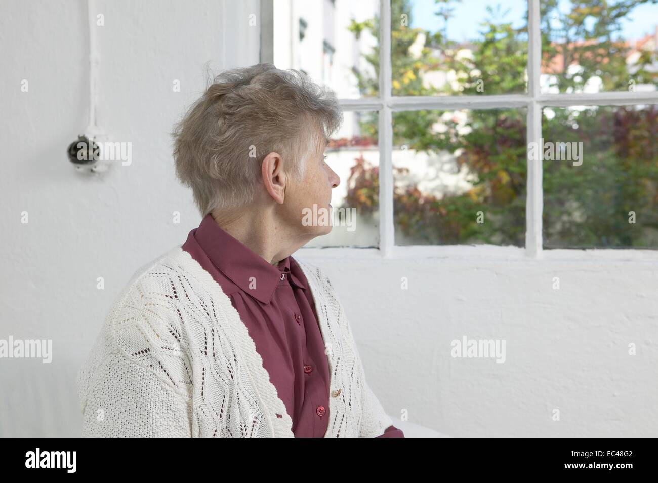 Aged Woman looking out of the Window Stock Photo - Alamy
