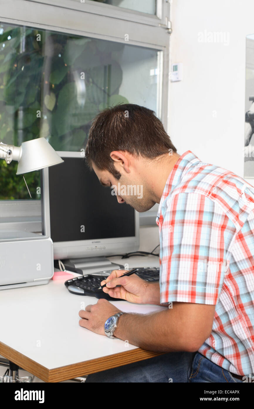 Man Sitting Writing at a Desk Stock Photo - Alamy