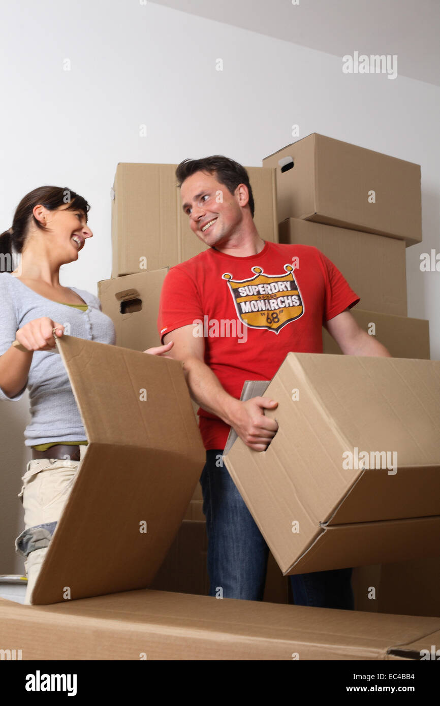 Young Woman Standing in Moving Box, Man Looking at her Stock Photo - Alamy