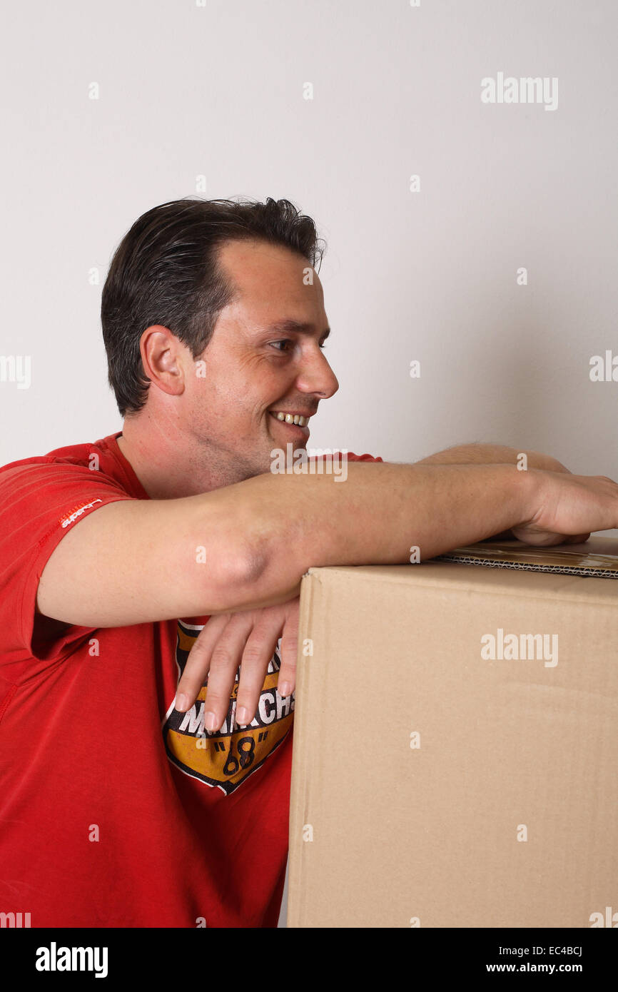 Man leaning on Cardboard Box Stock Photo - Alamy