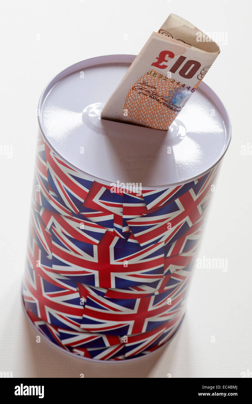 folded £10 note in money box with Union Jack flags on isolated on white ...