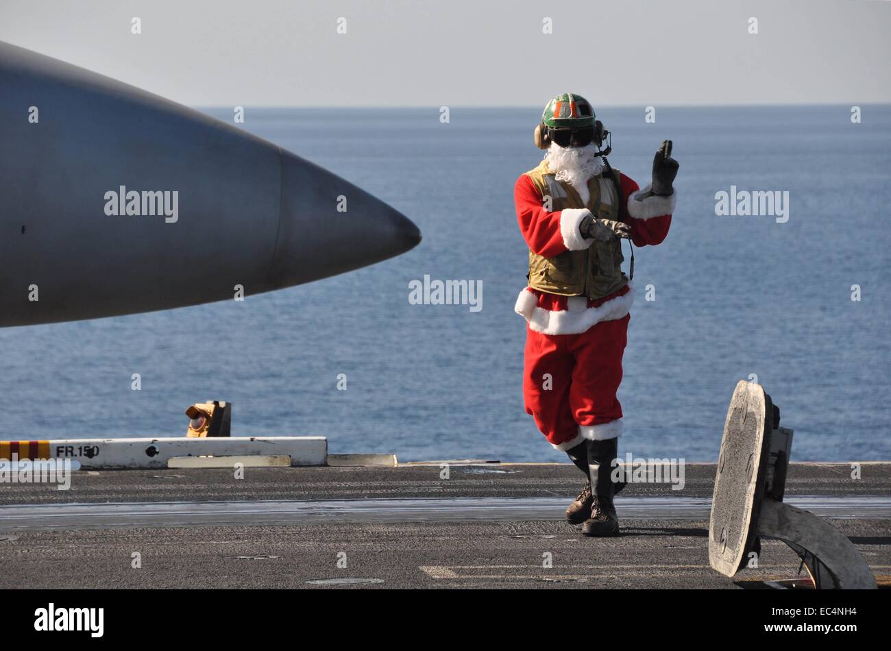 A US Navy sailor dressed as Santa Claus directs aircraft movement ...