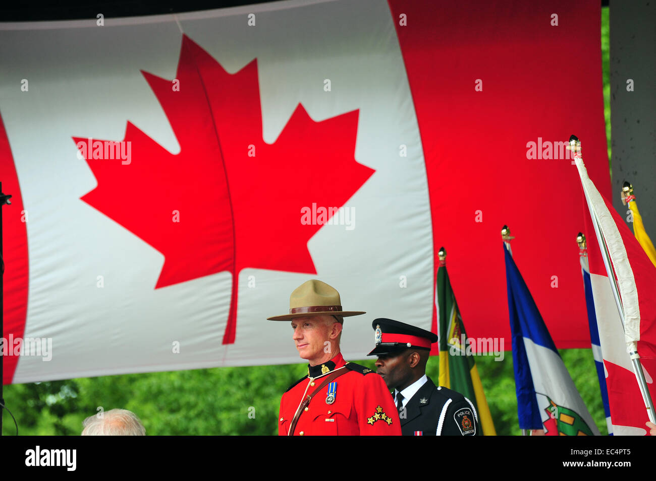 A Mounty stands in front of the Canadian flag during Canada Day ...