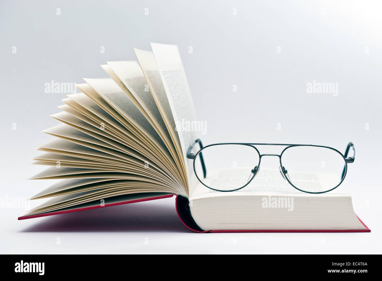 Reading glasses in an open book Stock Photo - Alamy