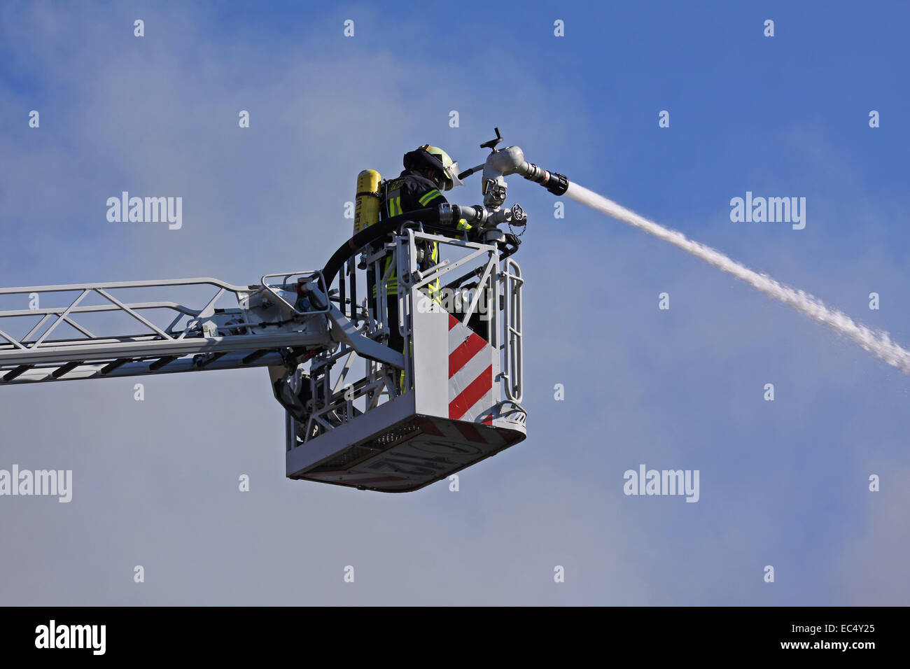 Firefighters fighting fire from bucket atop a fire truck Stock Photo ...
